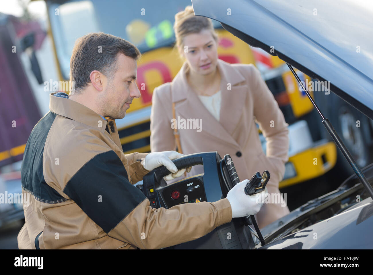Recovery man using jump starter on car Stock Photo - Alamy