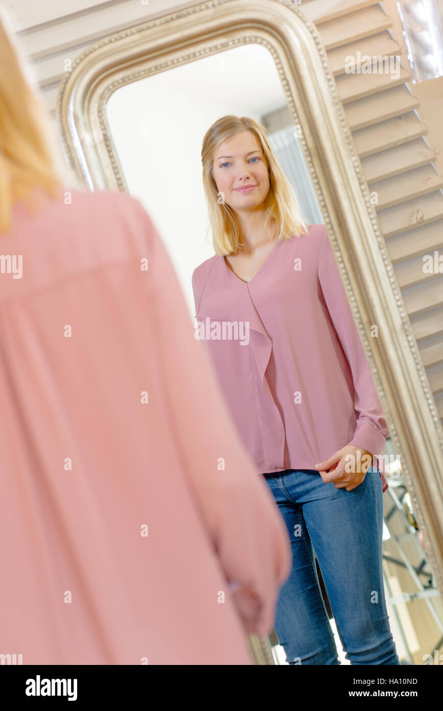 Lady looking at reflection in mirror Stock Photo - Alamy