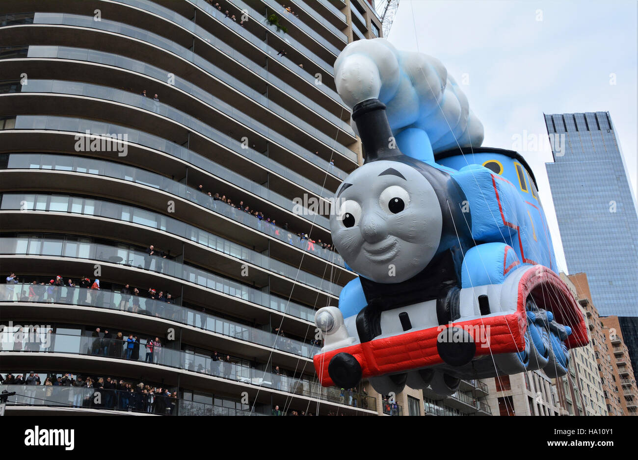 Spectators watching from balconies as Thomas The Tank Engine balloon ...