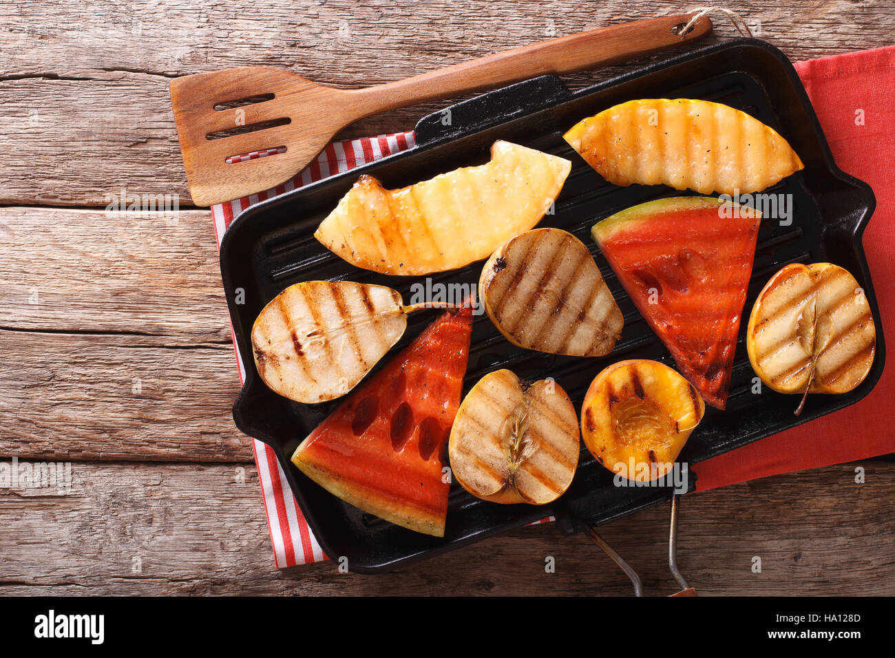 Delicious fruit apples, melon, pear, watermelon and peach on a grill ...