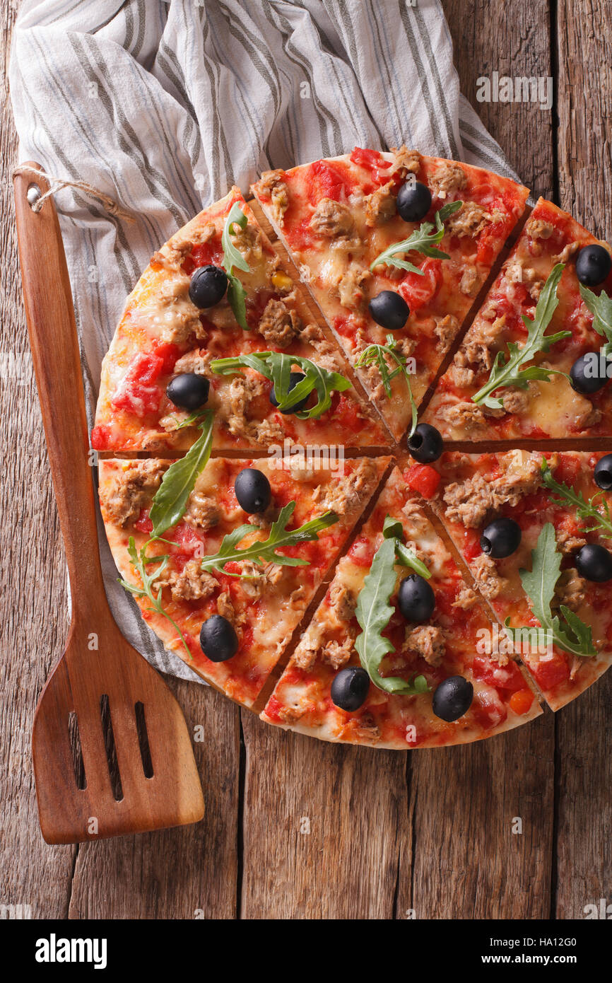 Fish Pizza with tuna, olives and arugula close-up on the table ...