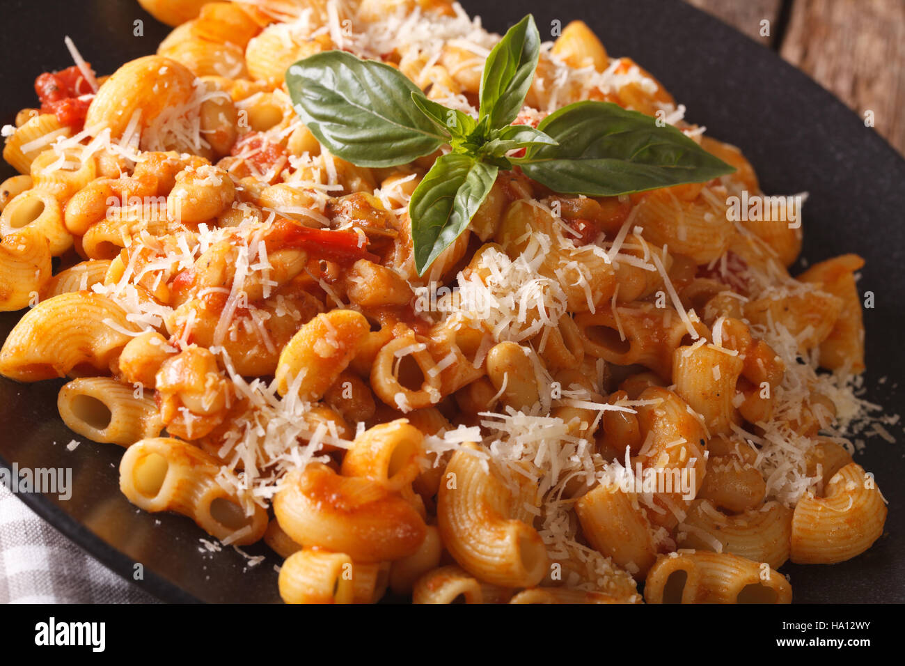 pasta gomiti with beans and parmesan cheese on a plate macro ...