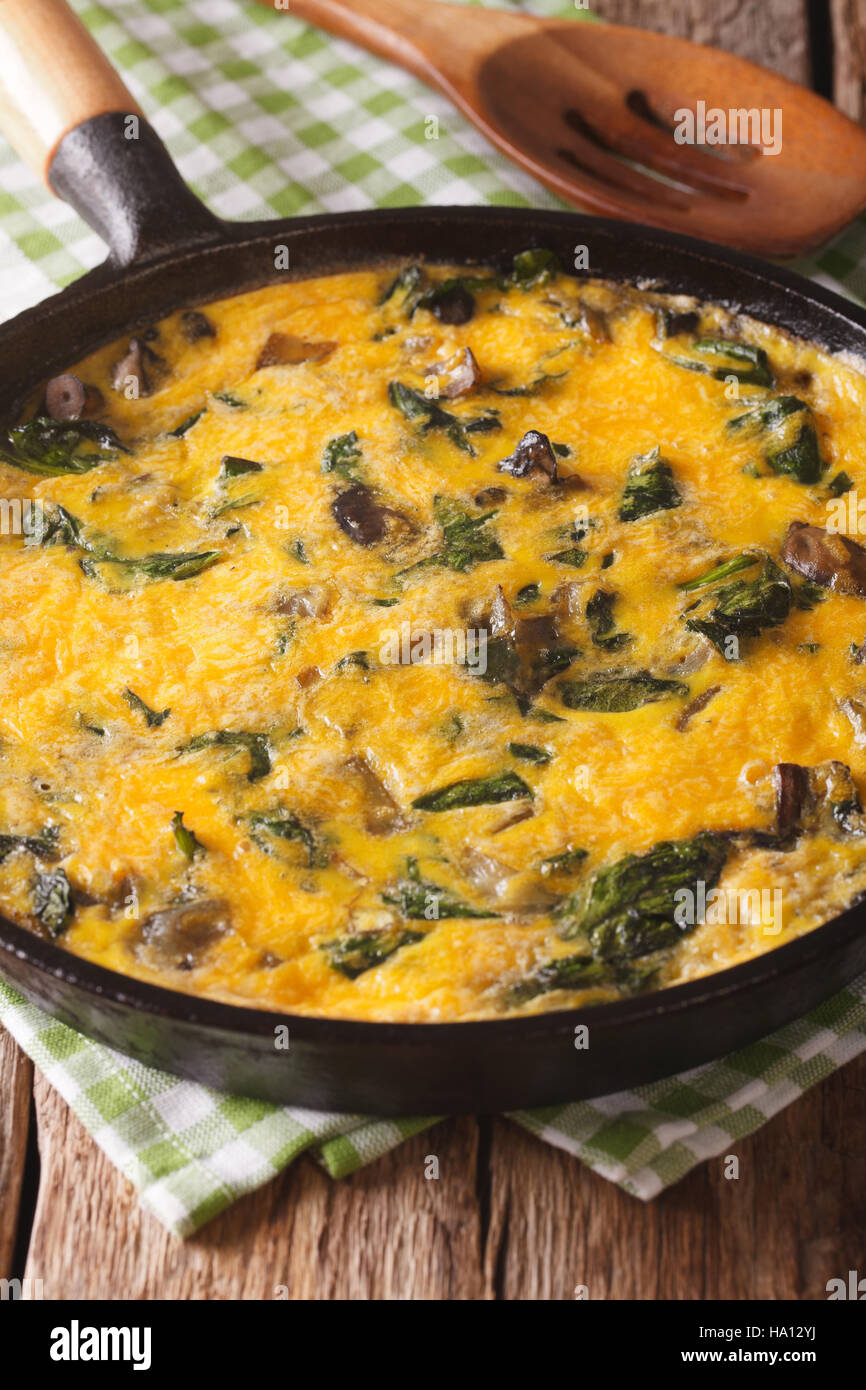 Italian omelette with spinach, cheddar cheese and mushrooms in a pan ...