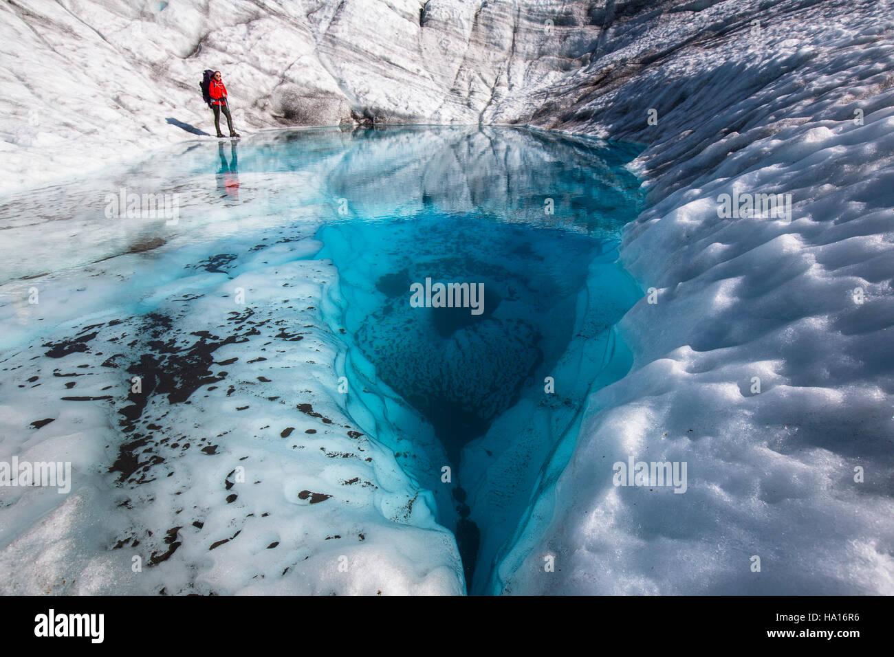 Backpackers explore a stunning pool on the Root Glacier in Alaska. This ...