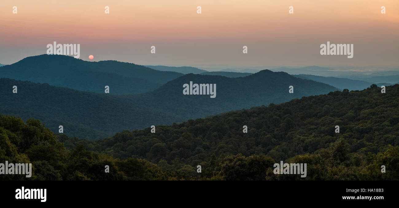 A hazy sunrise over the park captures the serene beauty of the ...