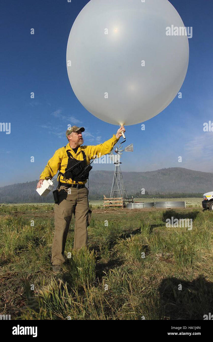 This image depicts a meteorologist using a weather balloon to study ...