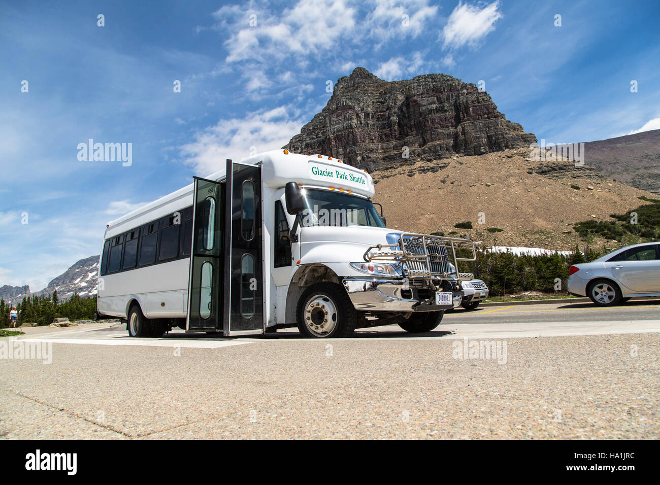 This image captures a shuttle bus at Logan Pass, Glacier National Park ...