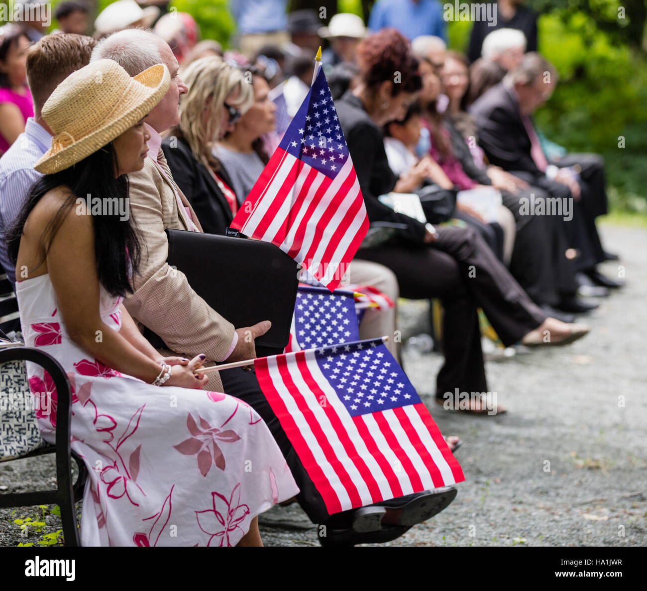 The image depicts a naturalization ceremony, where individuals become U ...