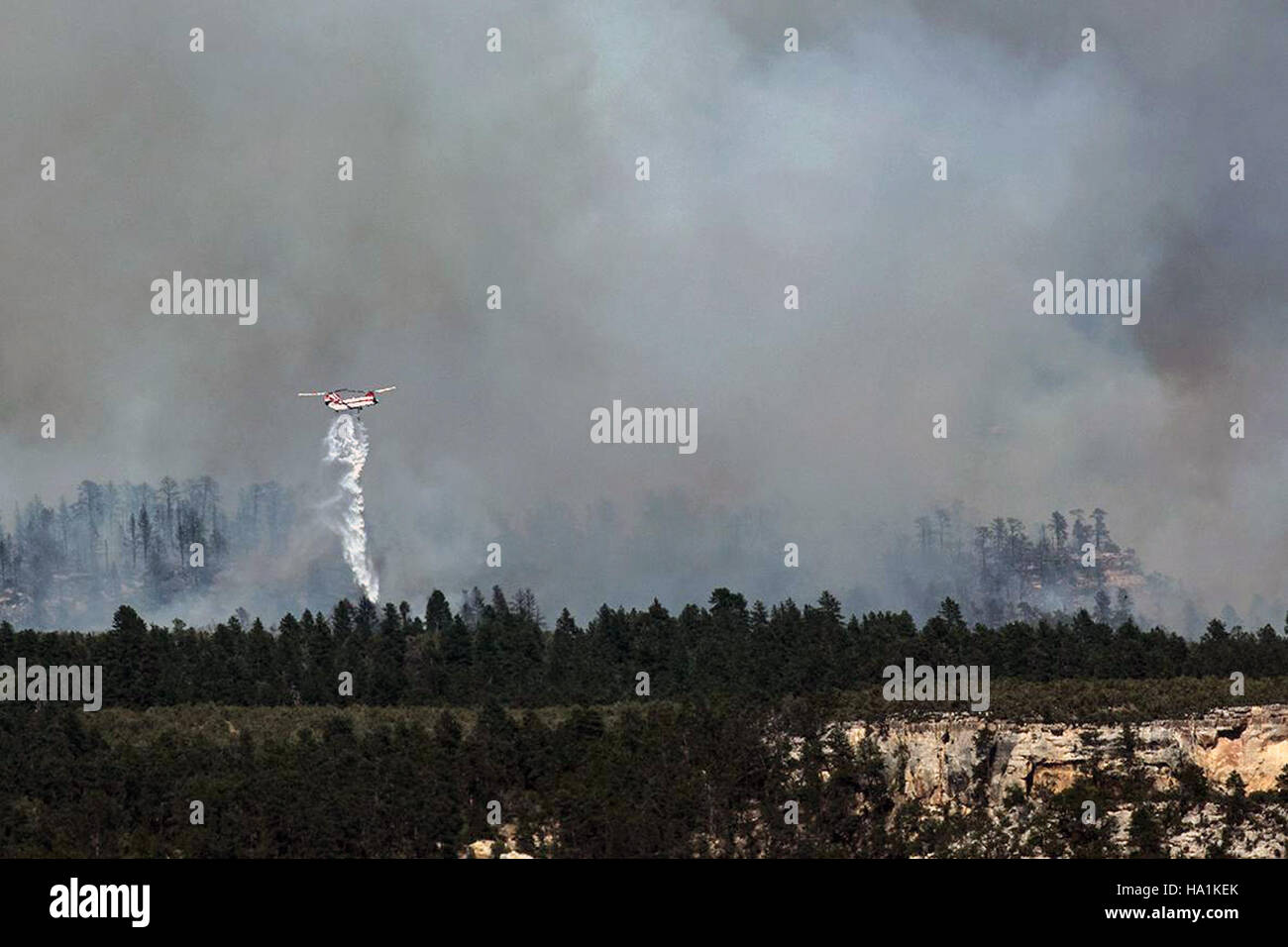 A wildfire in Wyoming is managed using a helicopter to drop water for ...