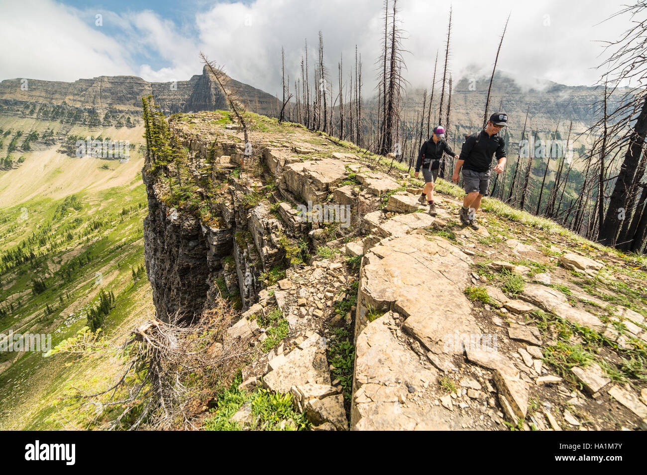 This image depicts hikers on the Tinkham Mountain Ridge in Glacier ...