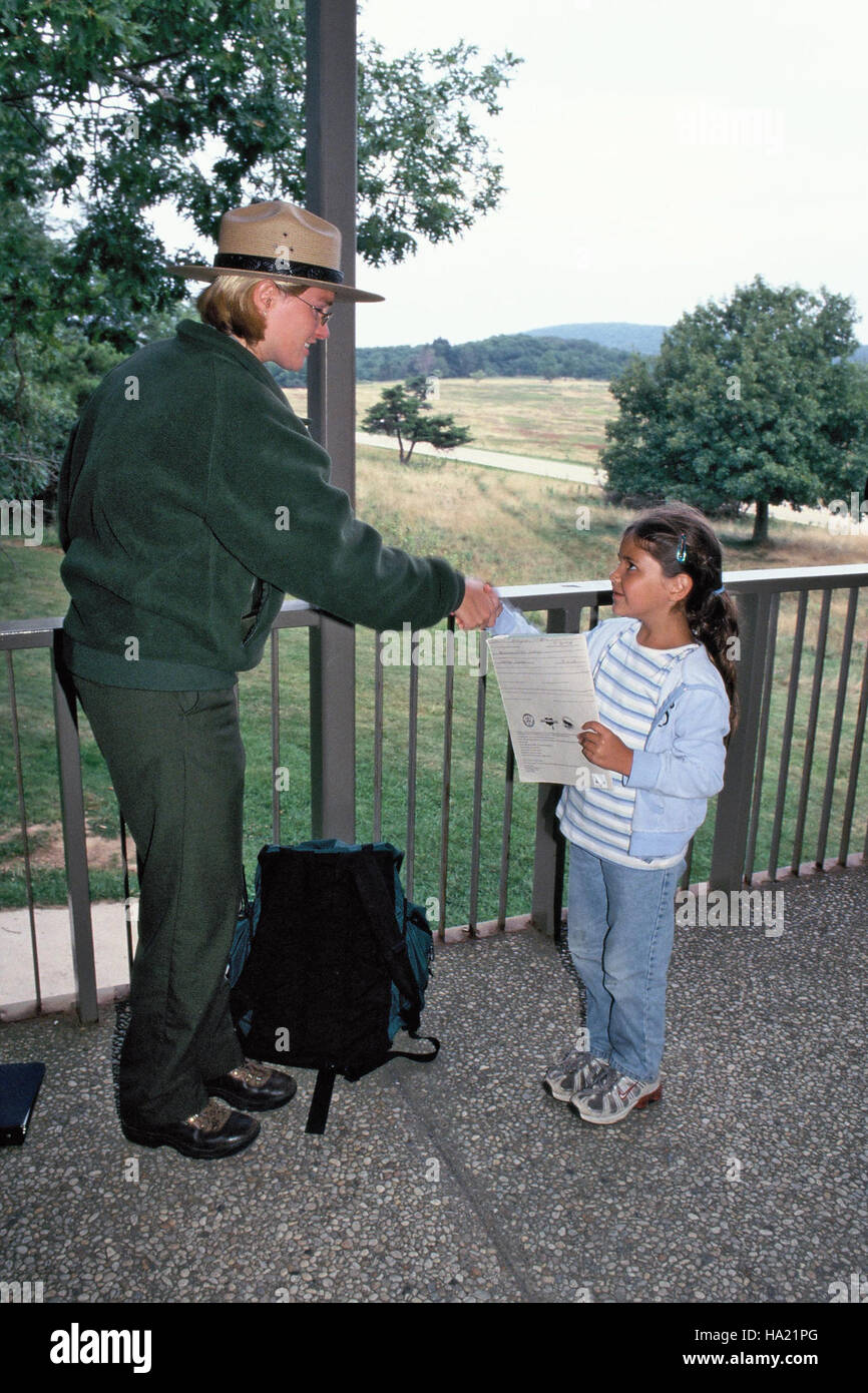 A park ranger congratulates a new Junior Ranger at a national park. The ...