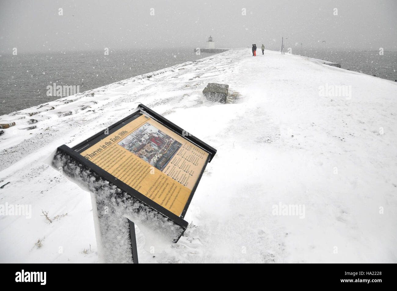 The image depicts Derby Wharf in Salem, Massachusetts, covered in snow ...