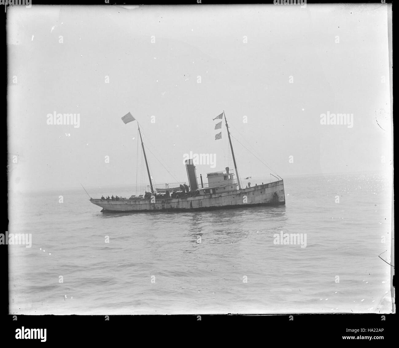 This photo, taken between 1900 and 1920, depicts a tugboat in a stream ...