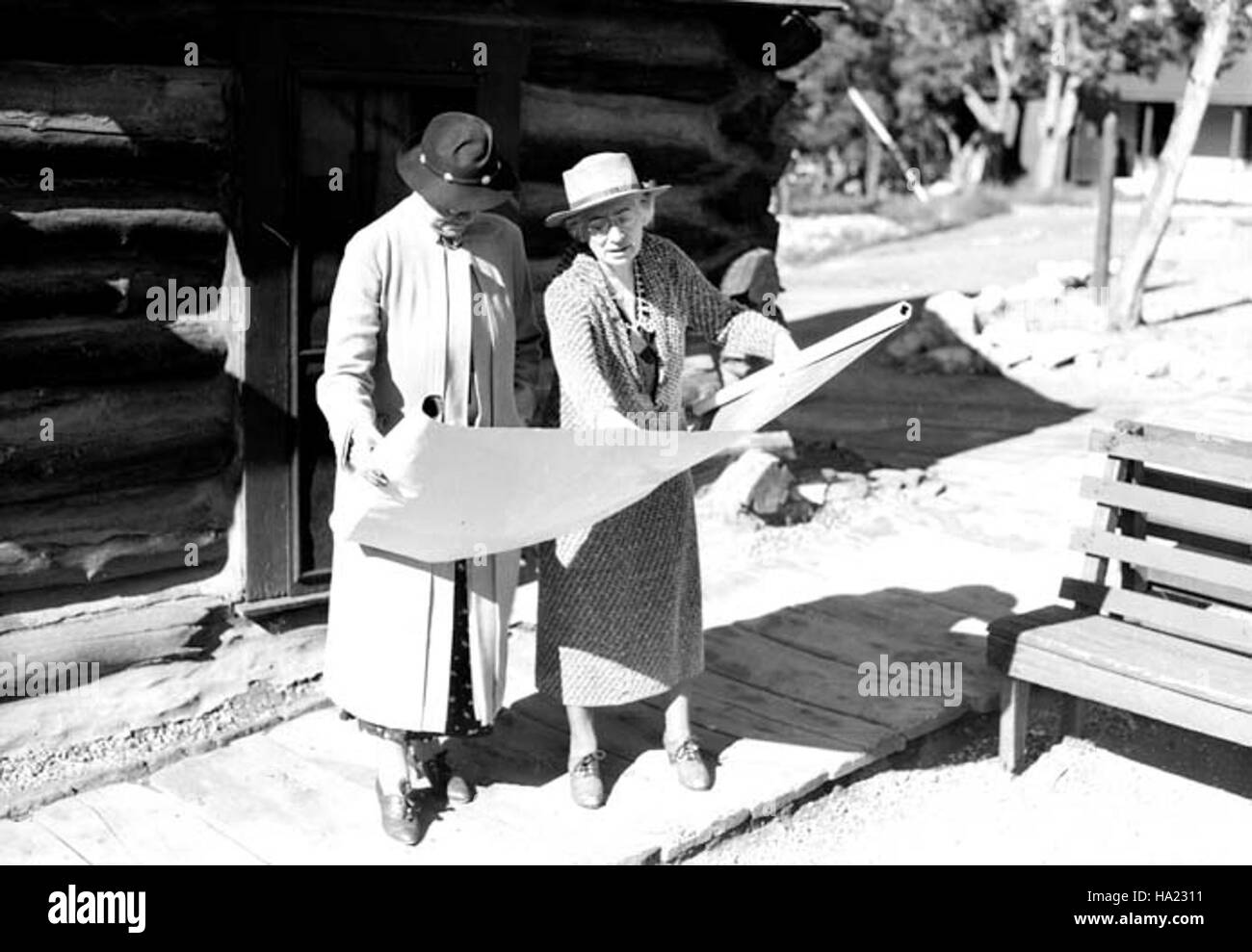 A historic photograph of architect Mary Colter reviewing blueprints for ...