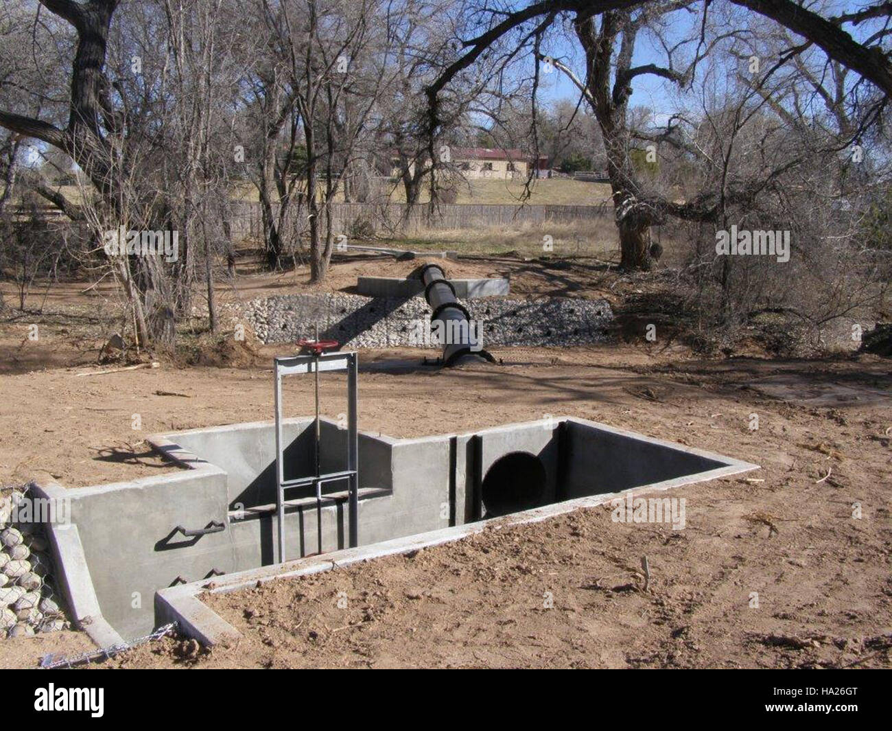 The image shows a sluice structure, flume, and concrete-lined ditch in ...
