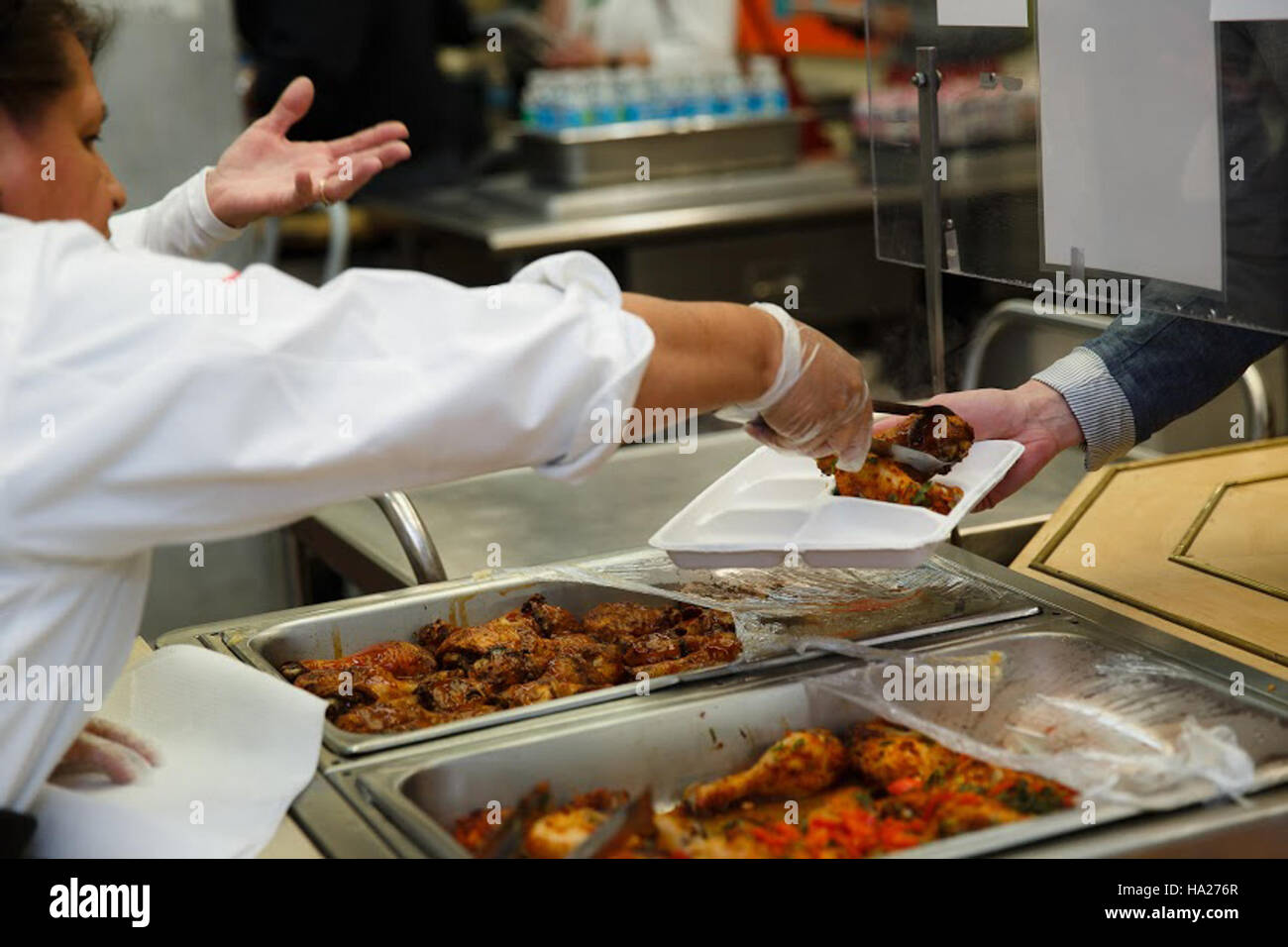At a USDA event, food service staff prepare and serve barbeque chicken ...