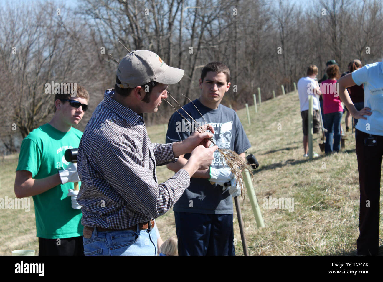An NRCS District Conservationist demonstrates tree planting techniques ...