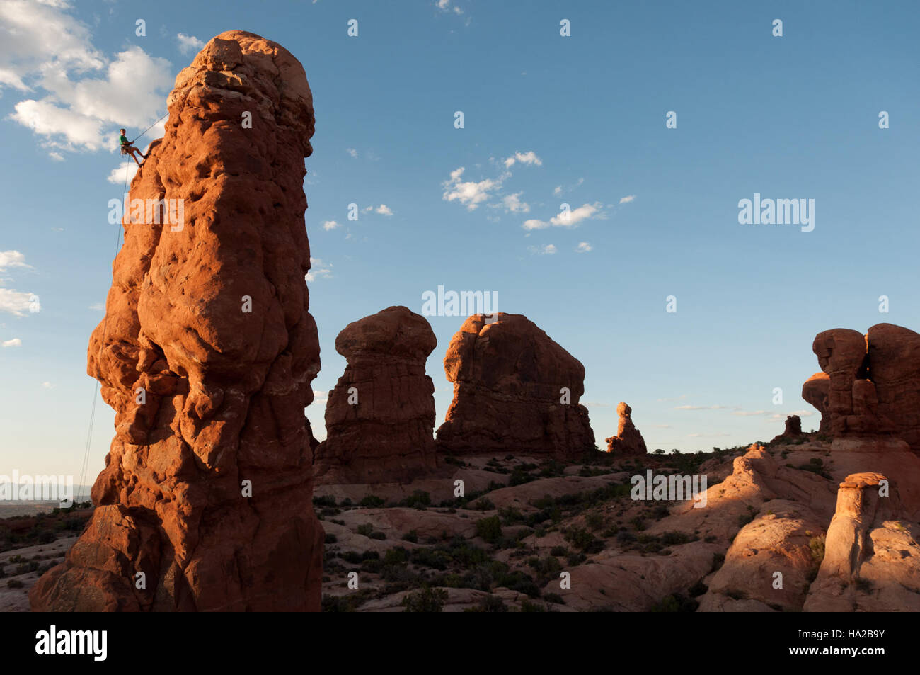 This image shows a climber rappelling down Owl Rock in Arches National ...
