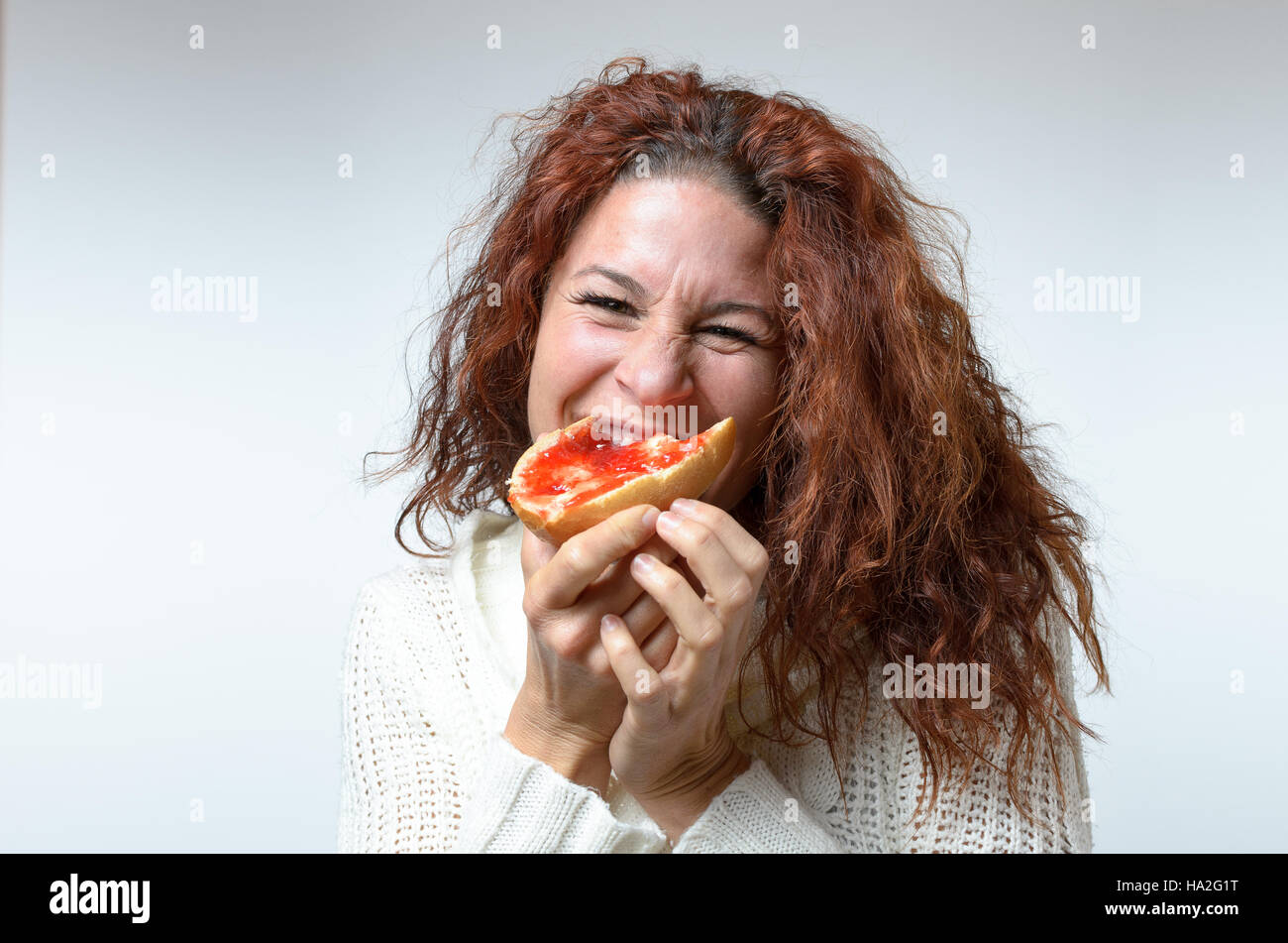 Young woman with curly long hair wearing stylish autumn fashion biting ...