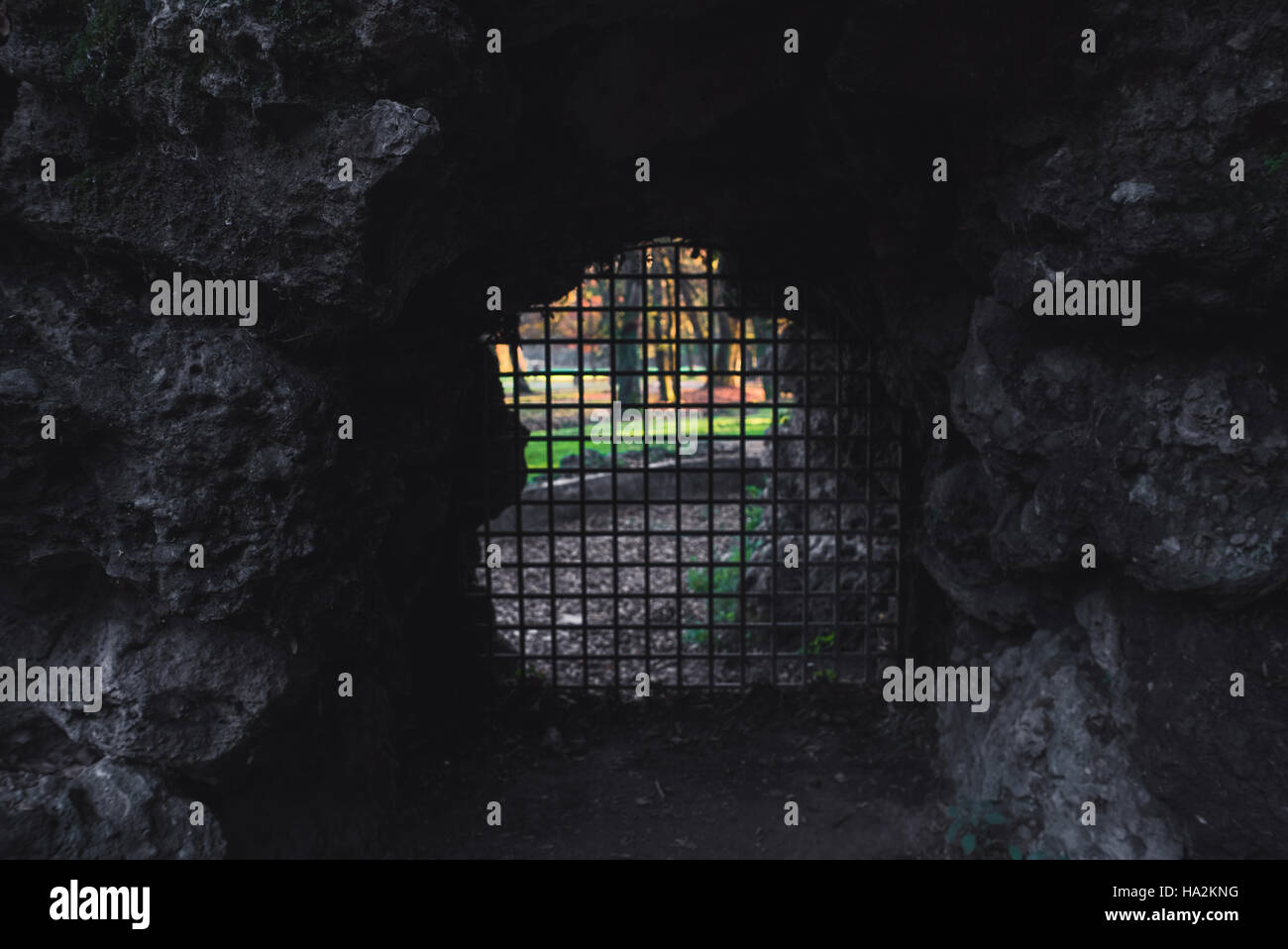 Creepy passage with grate between the rocks Stock Photo - Alamy