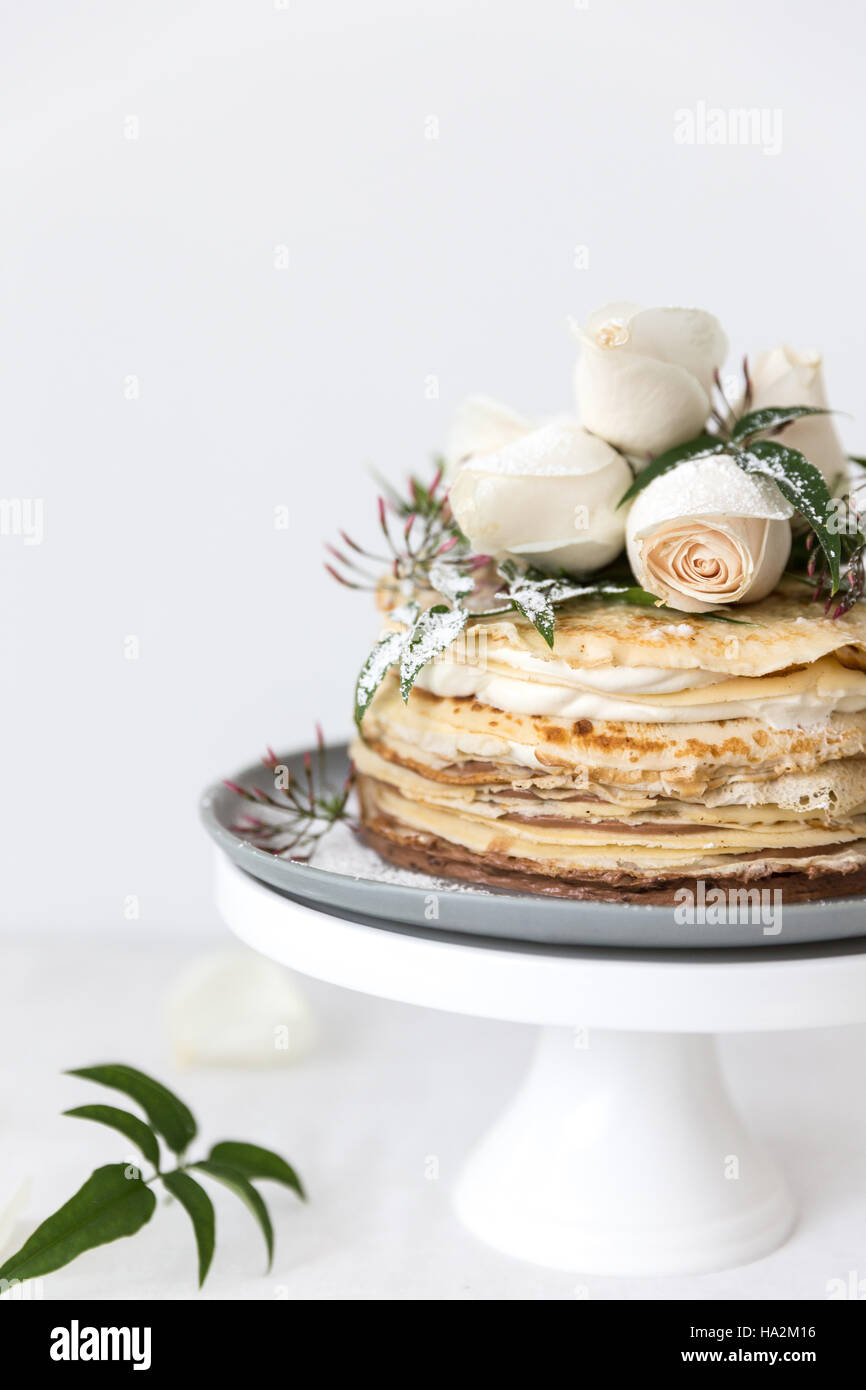 Layered Crepe Cake with cream and flower decoration Stock Photo - Alamy