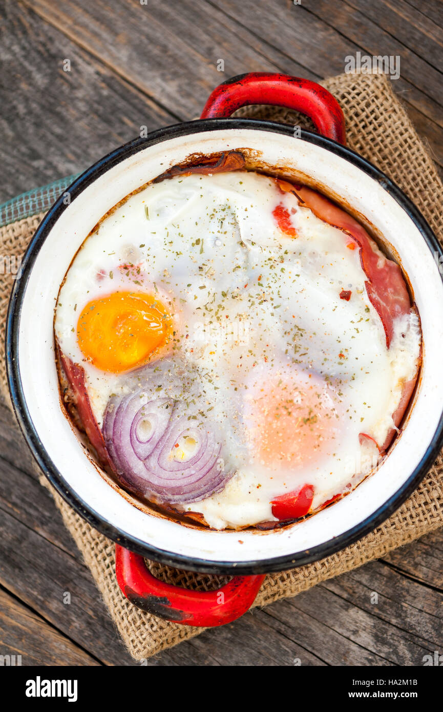 Baked eggs with red pepper, bacon and onion Stock Photo - Alamy