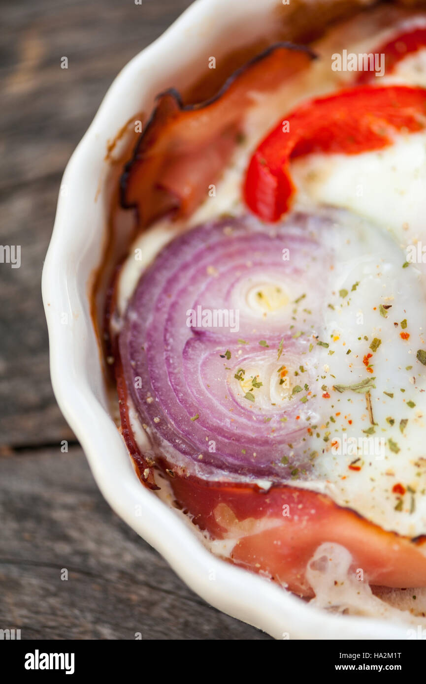 Baked eggs with red pepper, bacon and onion Stock Photo - Alamy