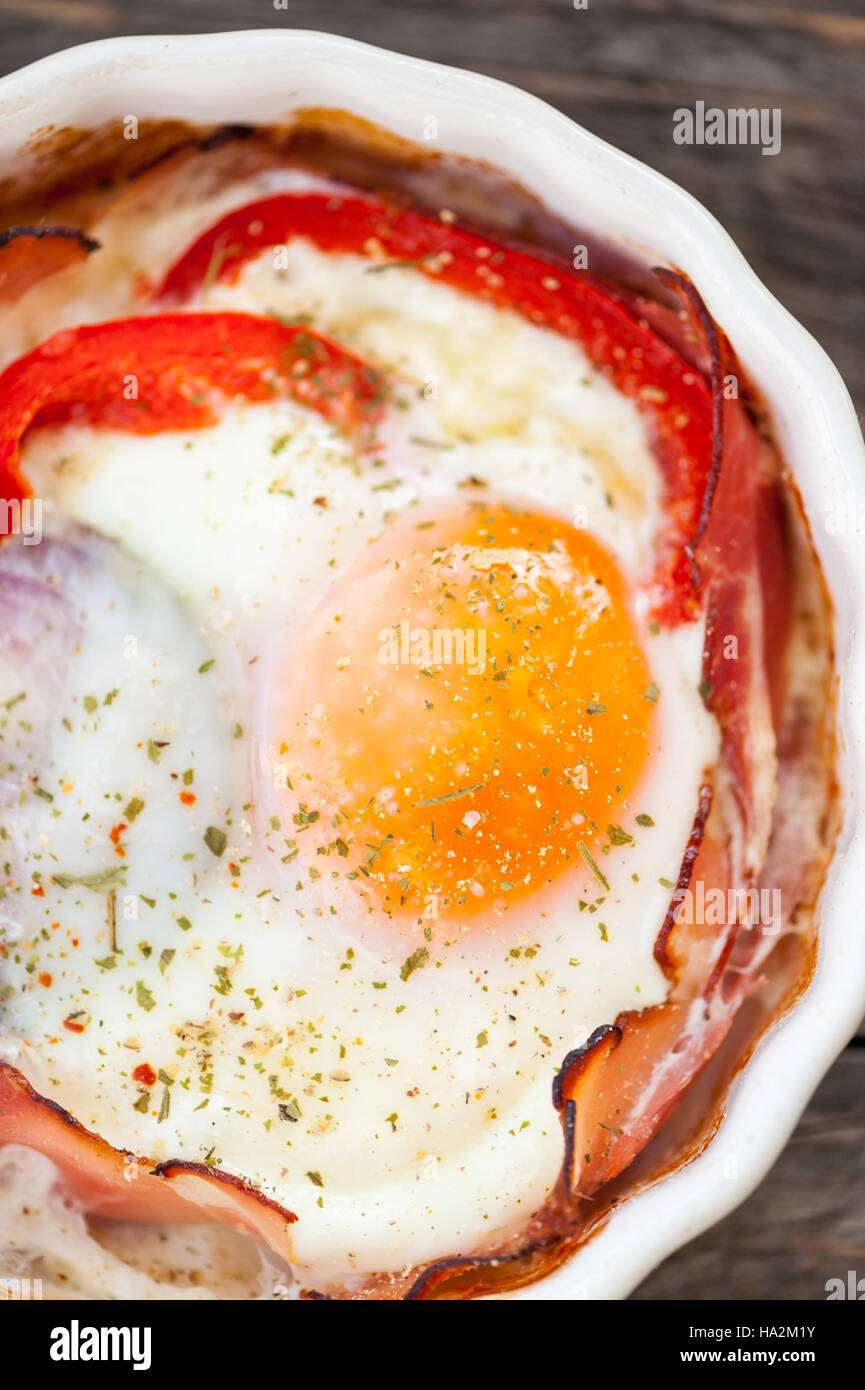 Baked eggs with red pepper, bacon and onion Stock Photo - Alamy