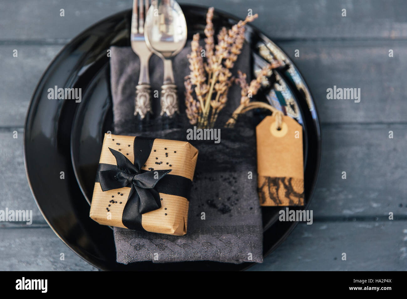 Place setting with wrapped gift Stock Photo - Alamy
