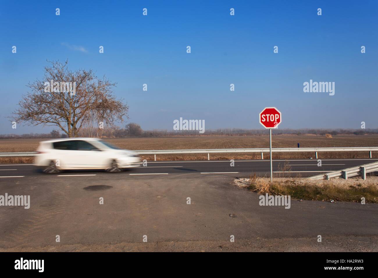 Stop Sign at Crossroads. Rural road. Exit onto the main road. Main road ...