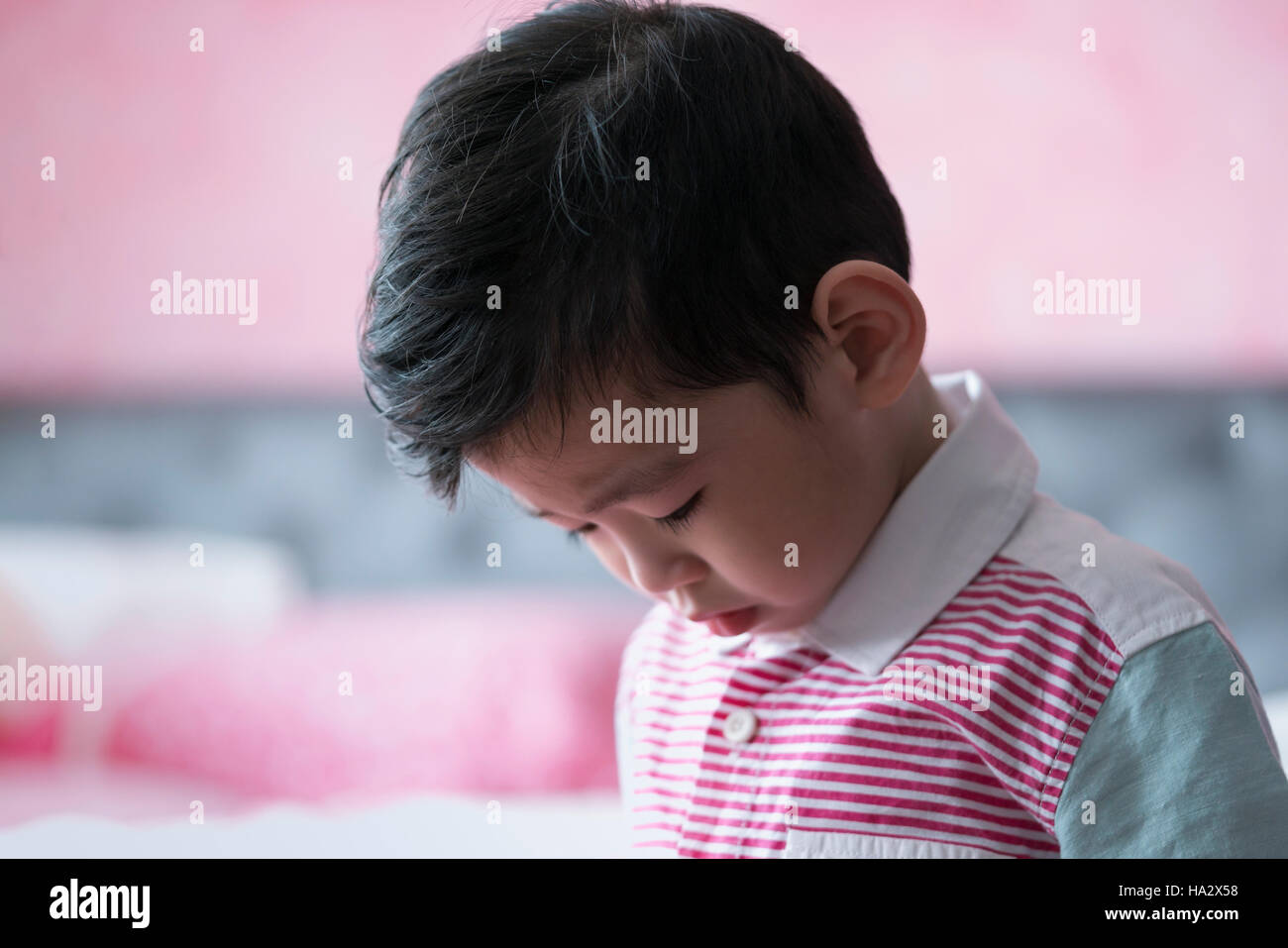 Sad boy looking at the floor Stock Photo - Alamy