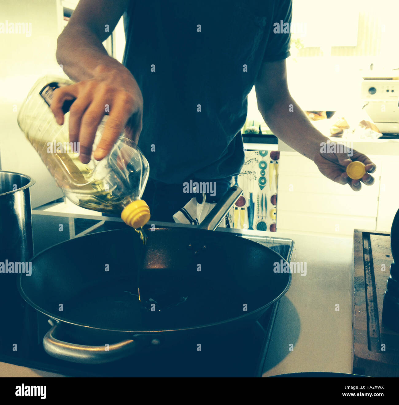 Man pouring cooking oil into a wok Stock Photo - Alamy