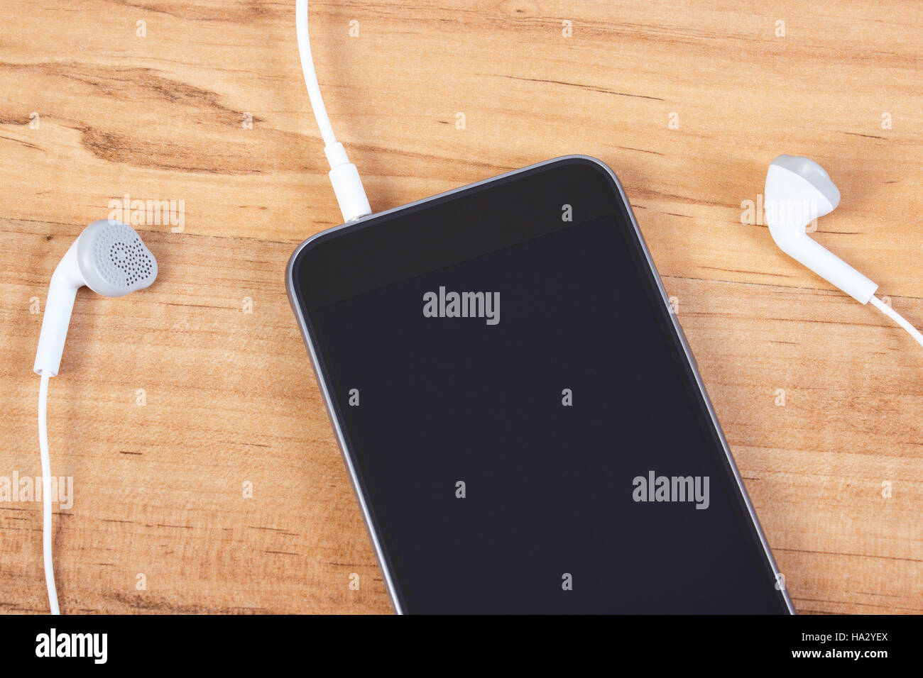 Mobile phone, smartphone with headphones on wooden board Stock Photo ...