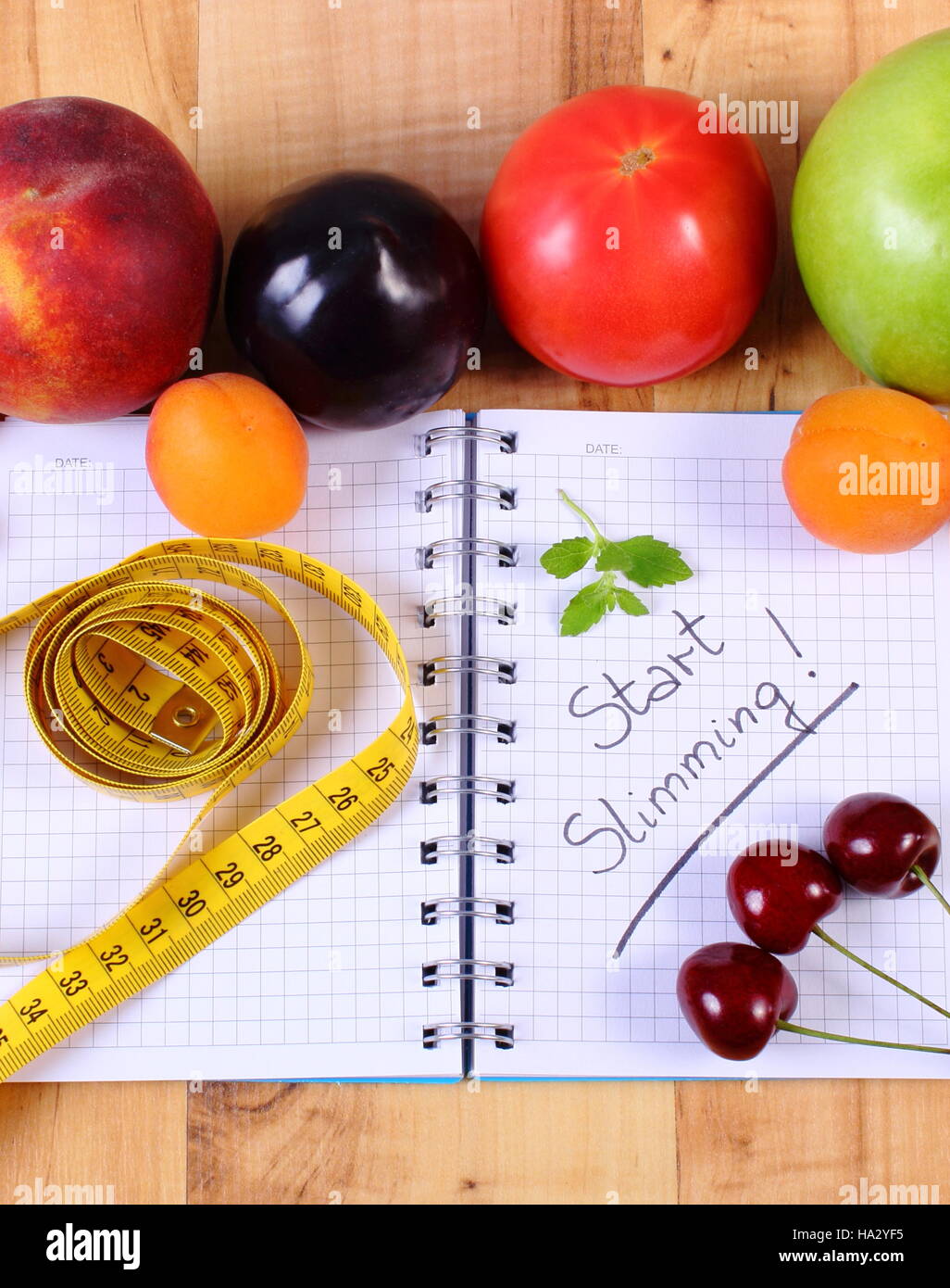 Fresh fruits and vegetables with tape measure and notebook for writing ...