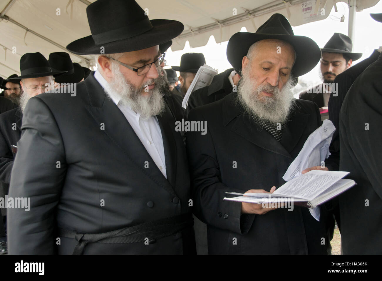 Two rabbis share a prayer book while waiting in line to visit to ...