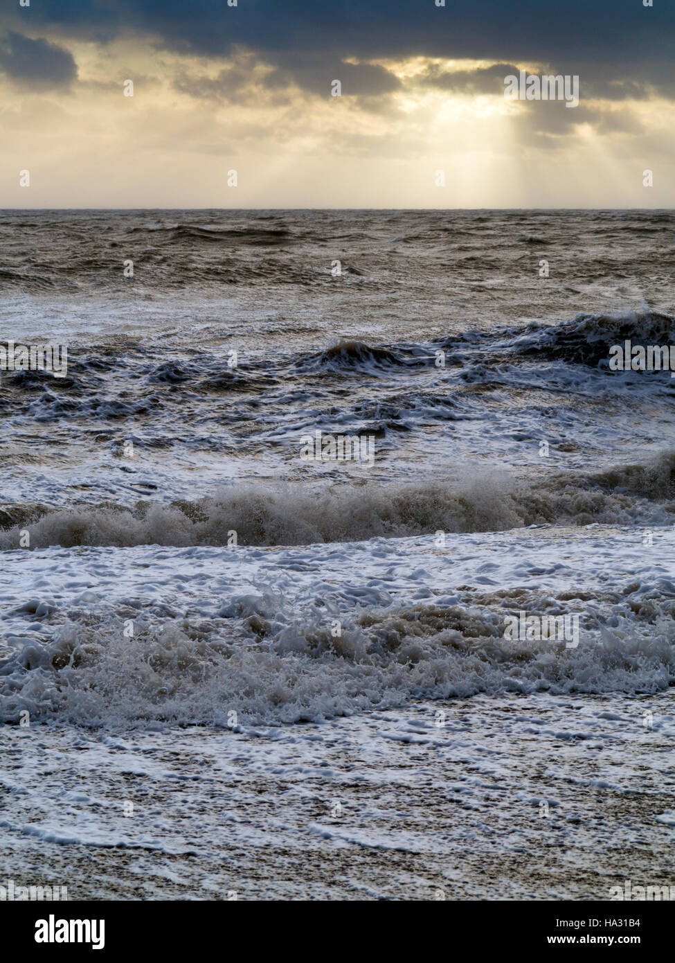 Churning waves breaking on the shoreline during heavy winds and spray ...