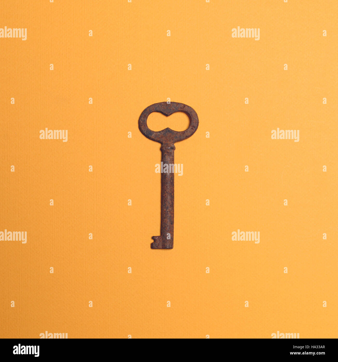 Old rusted key on yellow ocher background - Top view Stock Photo - Alamy