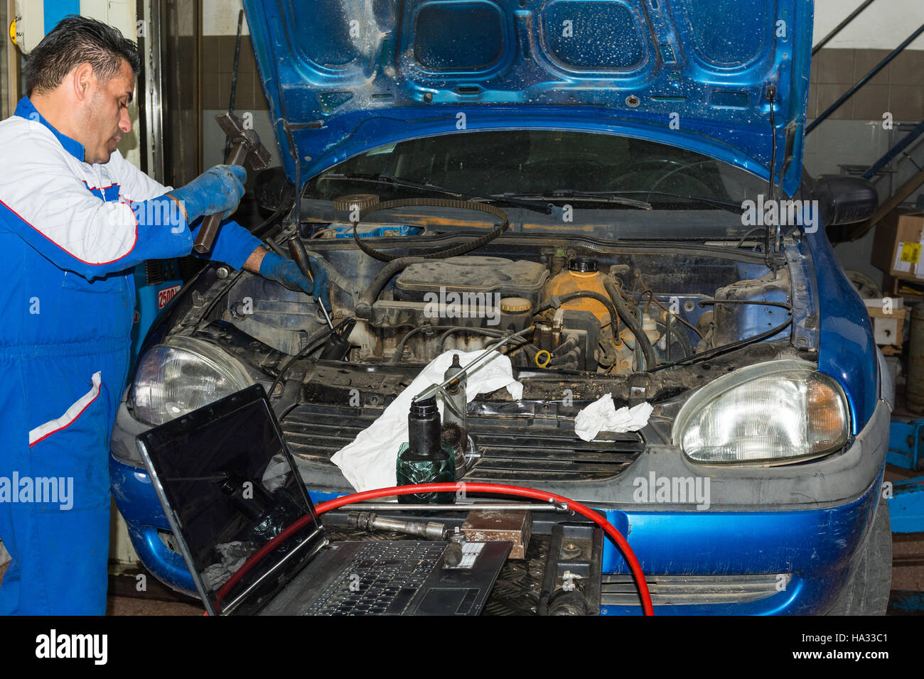 Car mechanic fixing an engine in his garage. copy space Stock Photo - Alamy