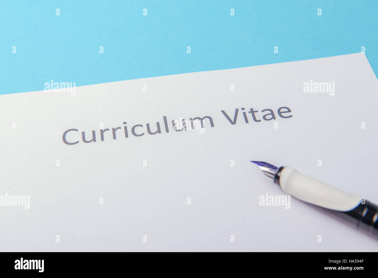 Curriculum vitae written on an blank white paper on blue background ...