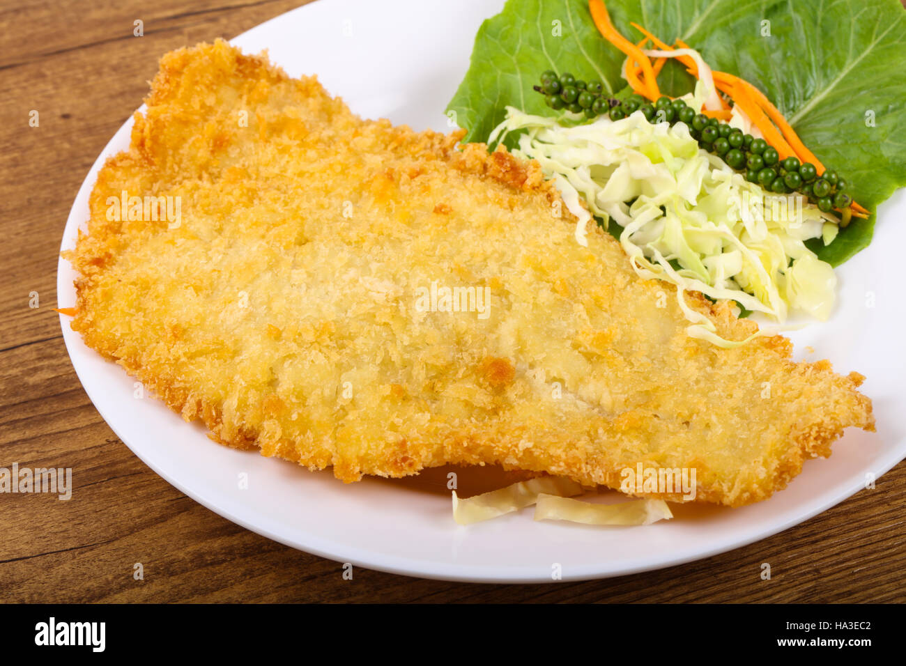 Fried Dory fish with salad on the wood background Stock Photo - Alamy