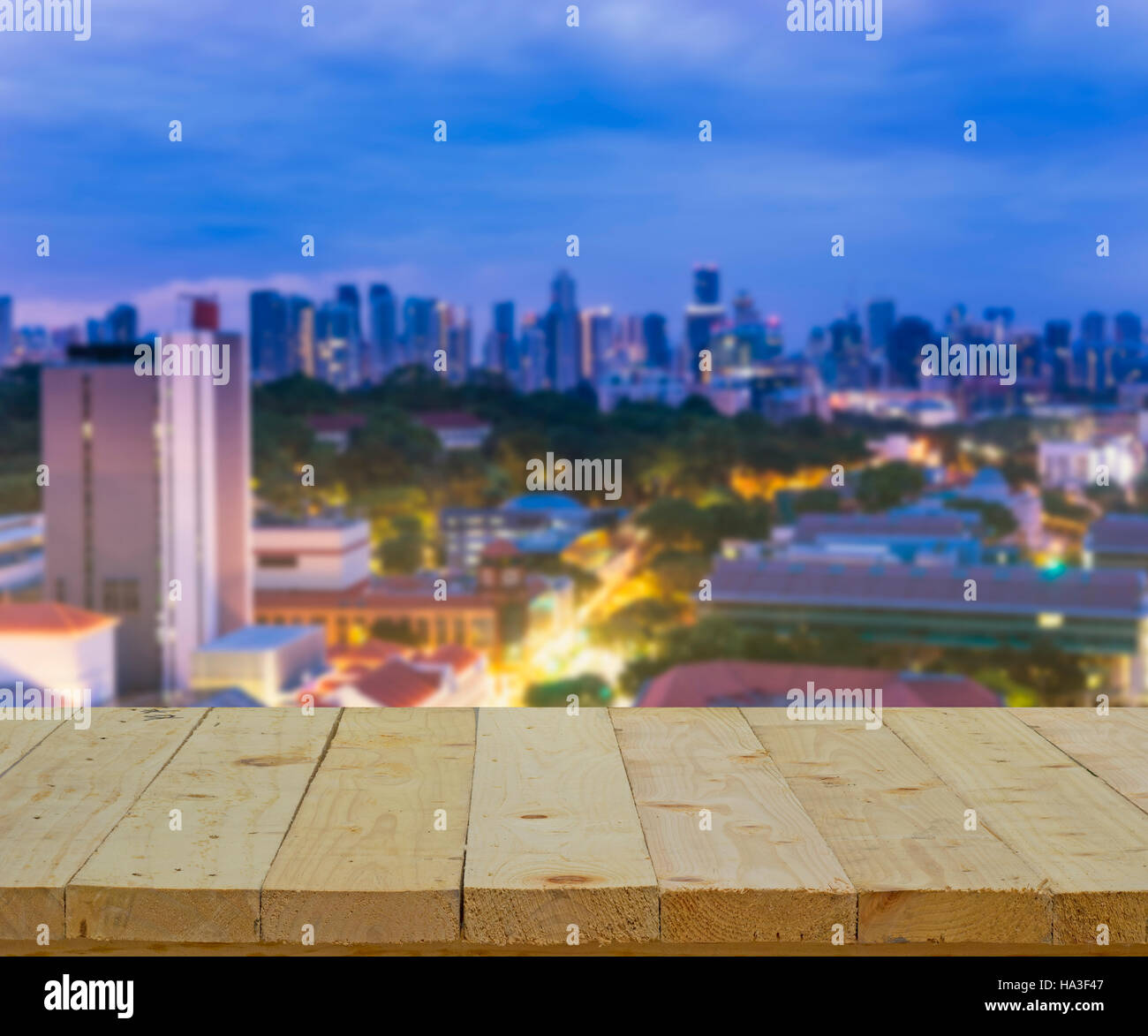 wood table top on abstract scene of urban cityscape in blue filter ...
