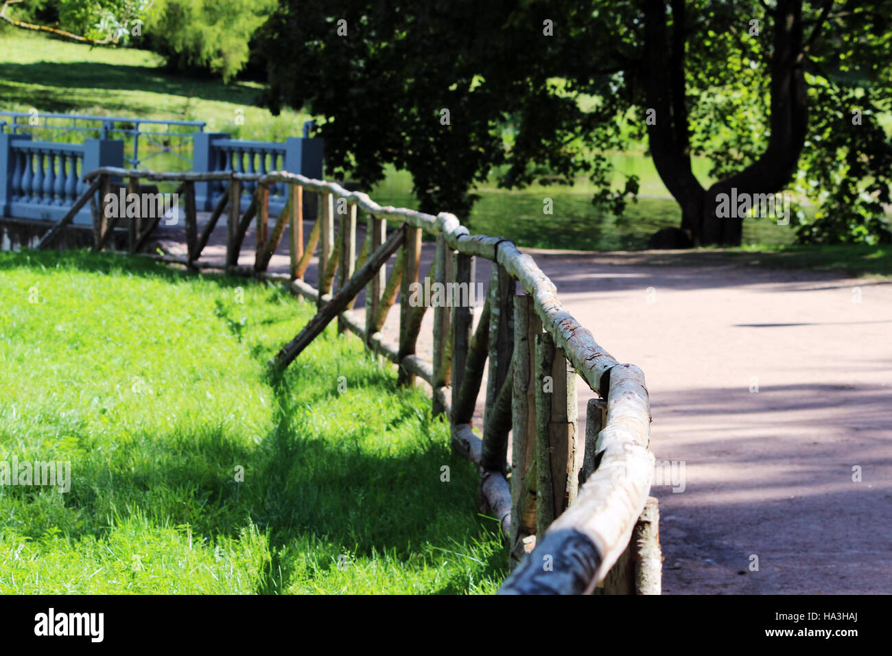 wooden fence separating the park road and lawn Stock Photo - Alamy