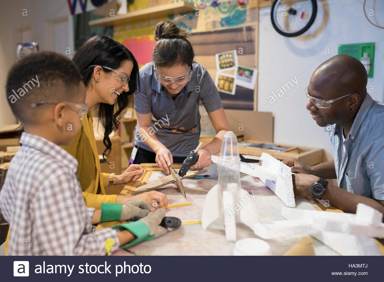 Scientist helping family in science center workshop Stock Photo - Alamy