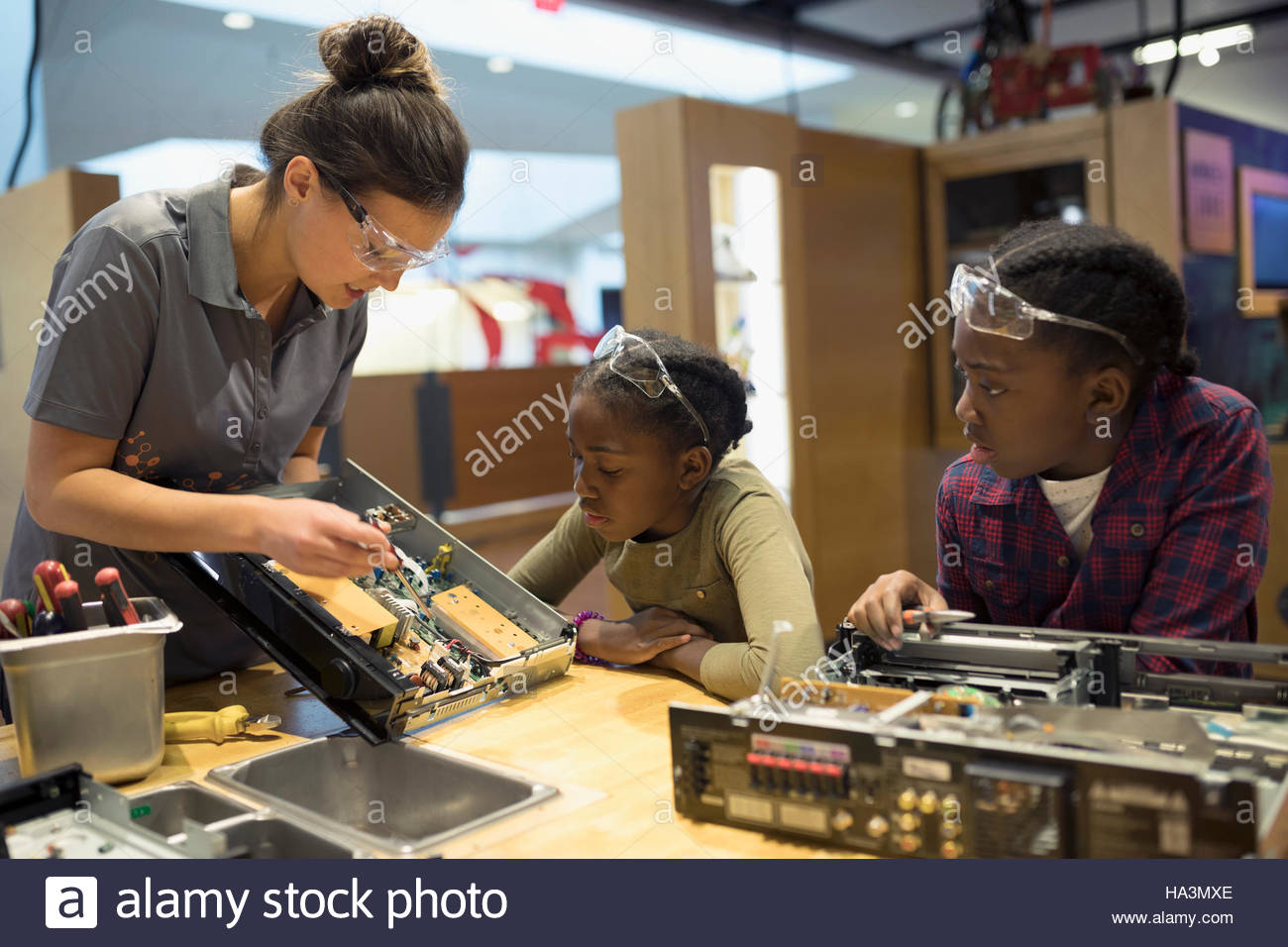 Scientist teaching twin sisters assembling electronics in science ...