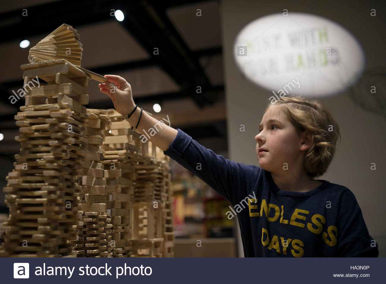 Girl stacking wood pieces in science center Stock Photo - Alamy
