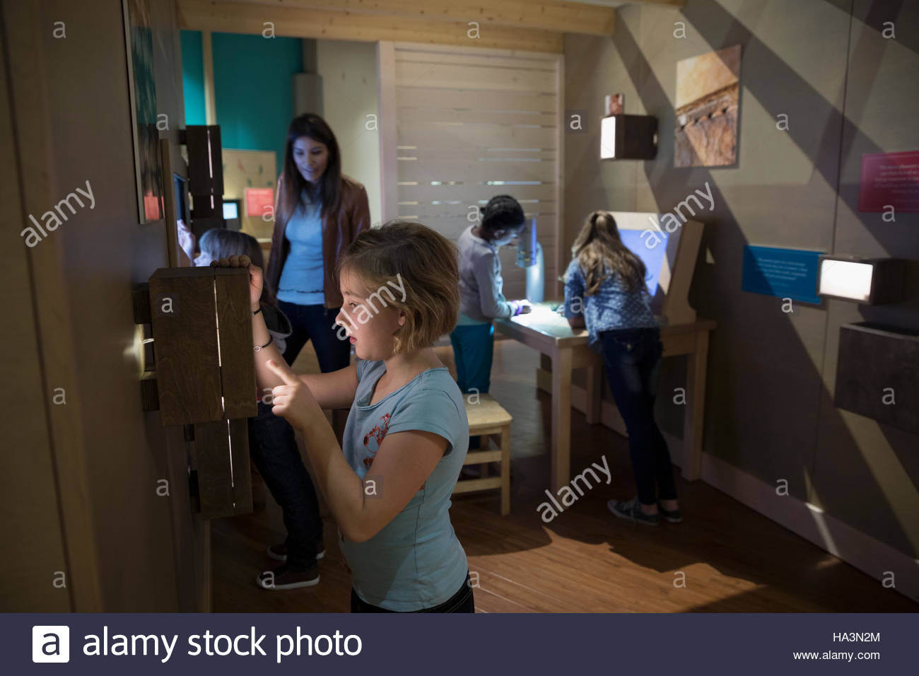 Curious girl watching display exhibit in science center Stock Photo - Alamy