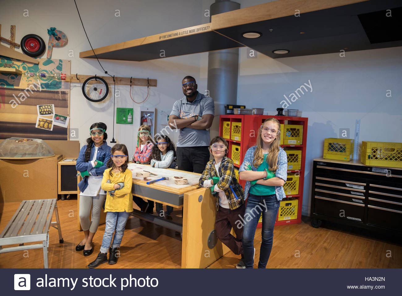 Portrait smiling scientist and children at workshop display in science ...