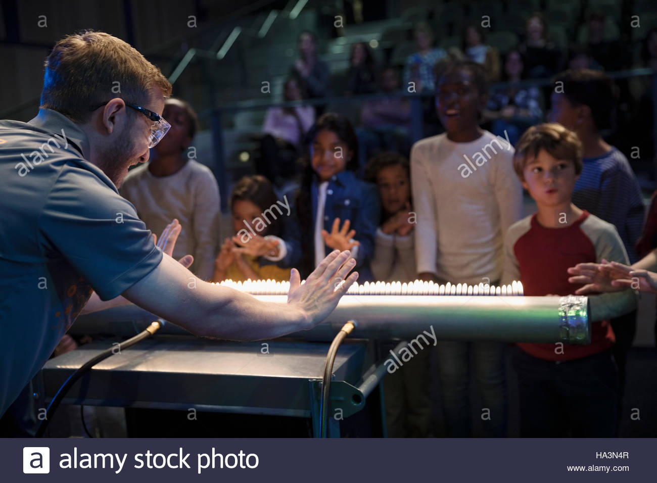 Children and scientist creating acoustic waves using a Rubens tube in ...