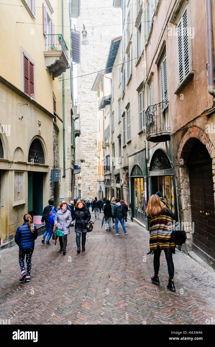 Shoppers walk along the cobbled streets of Citta Alta, Bergamo, Italy ...