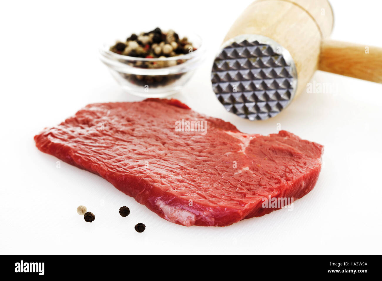 Beef minute steak and a meat mallet Stock Photo - Alamy